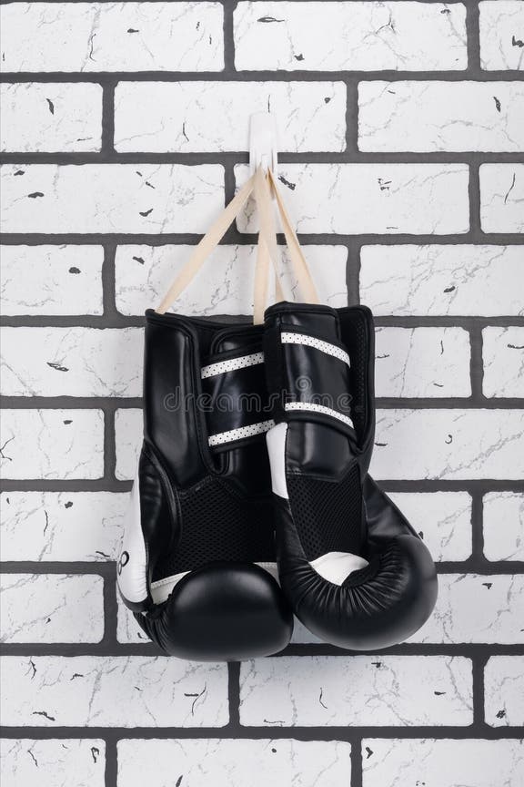 On the Brick Wall is a Hook on Which a Pair of Black Boxing Gloves ...