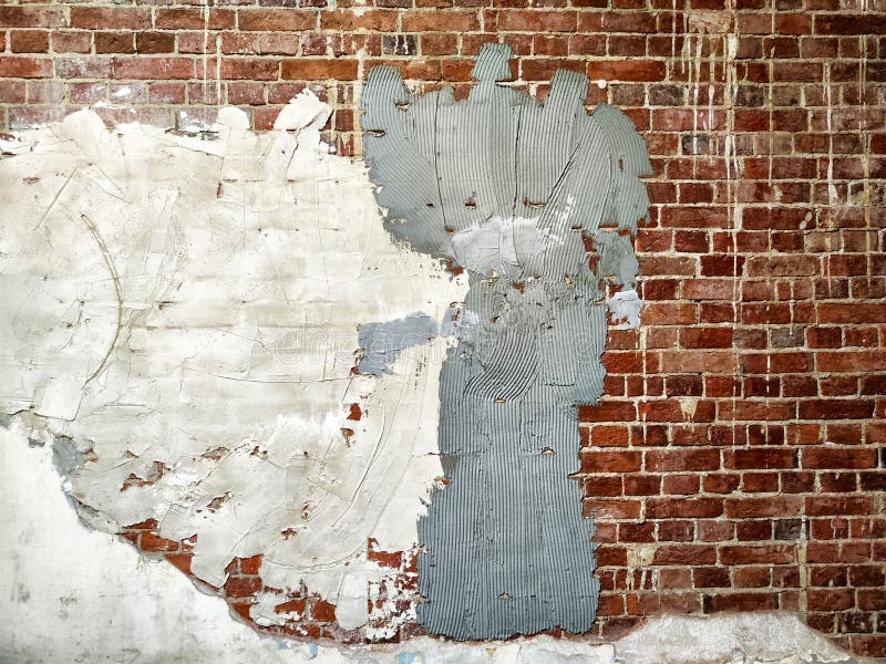 A Brick Wall with Sections of Plaster Removed and Unfinished Gray and ...
