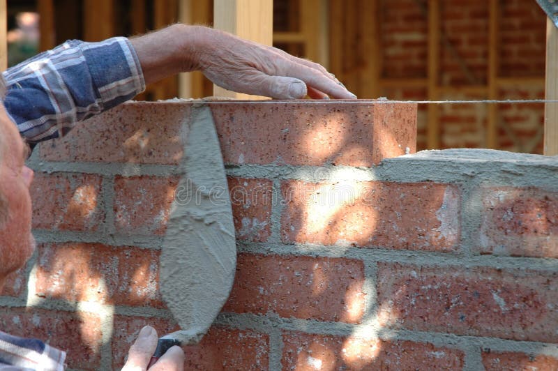 Mason laying brick stock photo. Image of tradesman, brick - 2112276