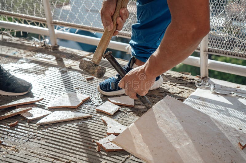 Bricklayer Breaking Some Floor Tiles. Working in a Construction Stock ...