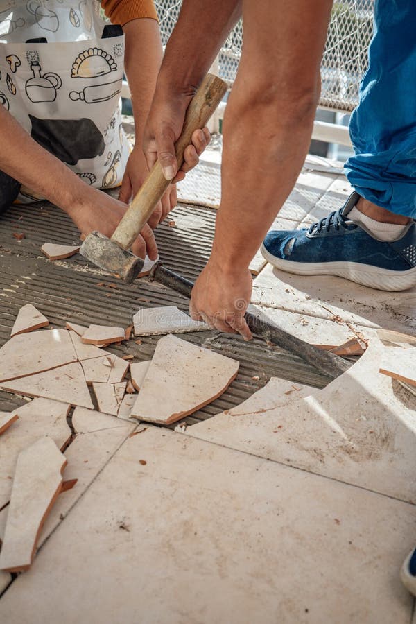 Bricklayer Breaking Some Floor Tiles. Working in a Construction Stock ...