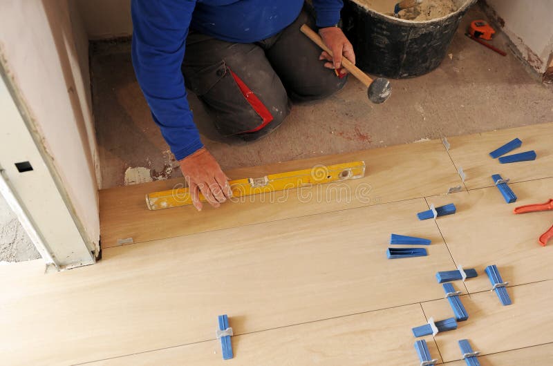 Bricklayer Checking the Leveling of a Porcelain Stoneware Floor with ...