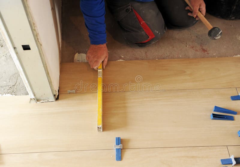 Bricklayer Checking the Leveling of a Porcelain Stoneware Floor with ...
