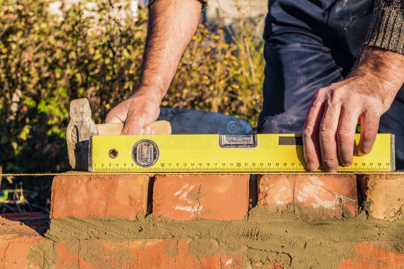 Bricklayer Checks the Horizontal Level of Brick Masonry Wall with a ...