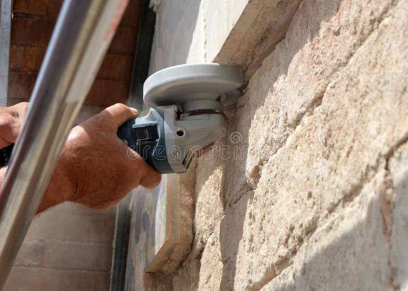Bricklayer Cutting an Old Solid Brick Wall with Electric Radial Cutter ...
