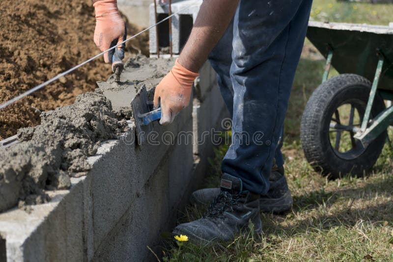 Bricklayer in Glove Spreading Concrete To Build a Wall on Construction ...
