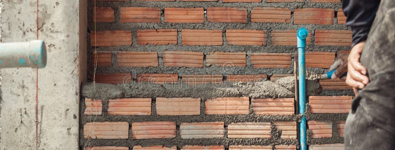 Bricklayer Installing Red Bricks and PVC Pipe in a New Wall Stock Photo ...