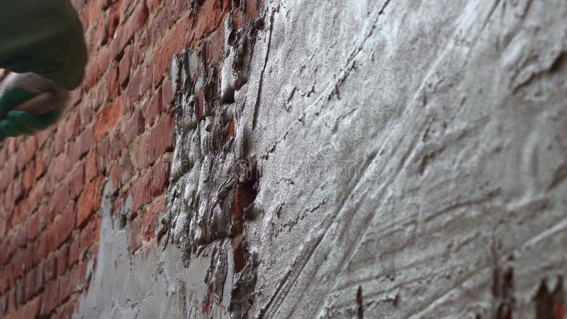 A Bricklayer Levels the Plaster on a Brick Wall with a Spatula ...