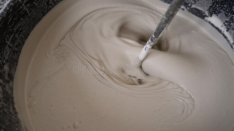 Bricklayer Mixes Cement in a Bucket. a Worker Using a Mixer Mixes the ...