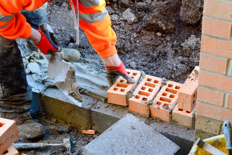 Bricklayer in Orange Hi-viz Laying Brick on Building Site Stock Photo ...