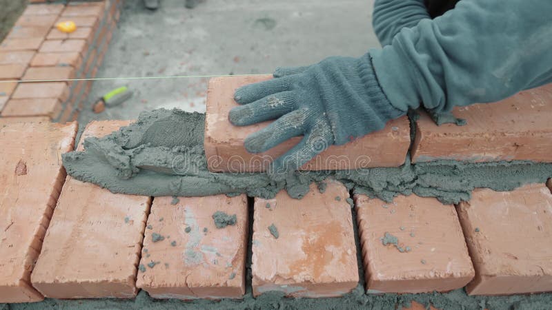 Bricklayer Placing Bricks with Mortar during Construction, Worker Using ...