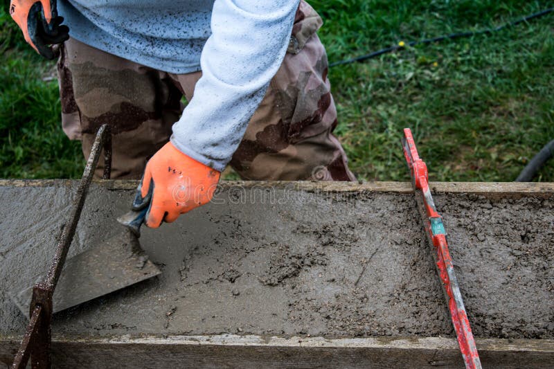 Bricklayer Spreading Concrete with a Trowel and Level To Build a Wall ...