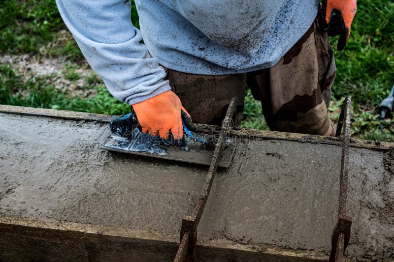 Bricklayer Spreading Concrete with a Trowel and Level To Build a Wall ...