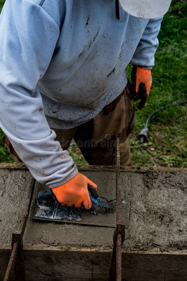 Bricklayer Spreading Concrete with a Trowel and Level To Build a Wall ...