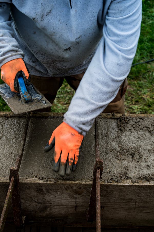 Bricklayer Spreading Concrete with a Trowel and Level To Build a Wall ...