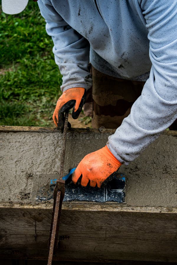 Bricklayer Spreading Concrete with a Trowel and Level To Build a Wall ...