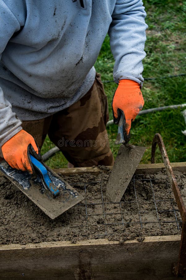 Bricklayer Spreading Concrete with a Trowel and Level To Build a Wall ...