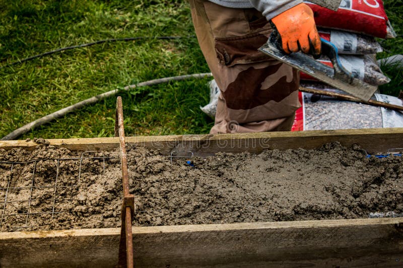 Bricklayer Spreading Concrete with a Trowel and Level To Build a Wall ...