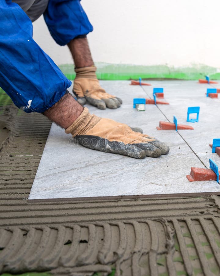 Tiler at Work Installing New Floor with Tiles. Construction Stock Image ...
