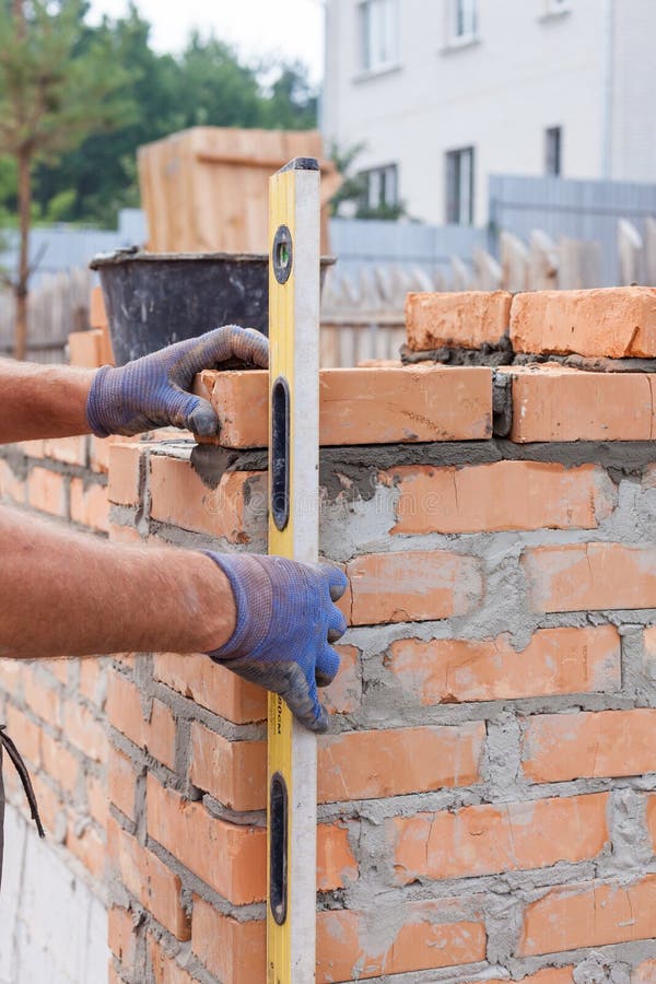 Bricklayer Using a Building Levell To Check New Red Brick Wall Outdoor ...