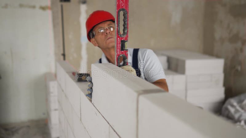 Bricklayer Using Rubber Mallet Hammer To Tap and Level Concrete Blocks ...