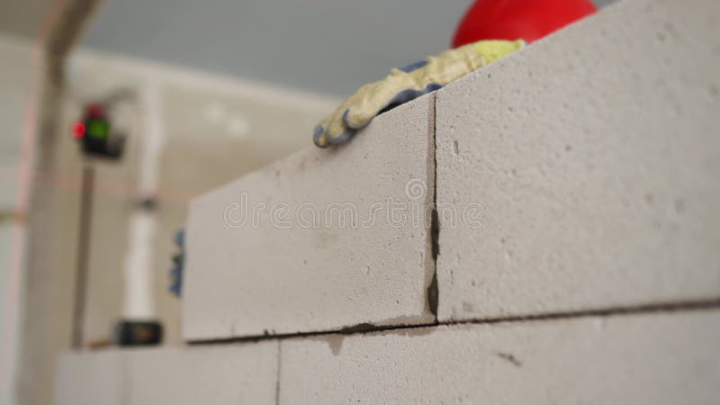 Bricklayer Using Rubber Mallet Hammer To Tap and Level Concrete Blocks ...