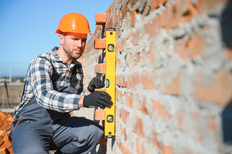 Bricklayer Using a Spirit Level To Check New Red Brick Wall Outdoor ...