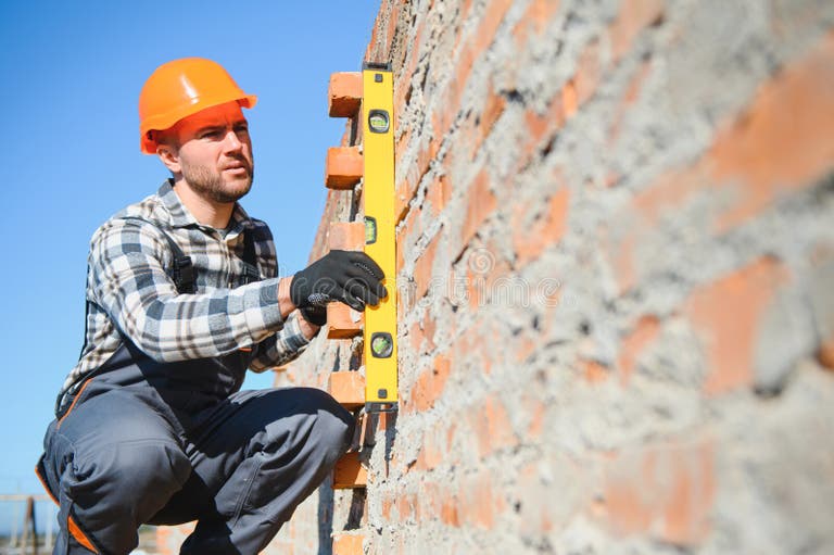 Bricklayer Using a Spirit Level To Check New Red Brick Wall Outdoor ...