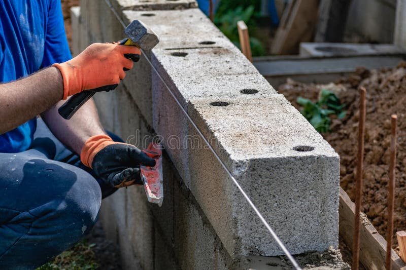 A Bricklayer Works on Blocks To Build a Wall on a Construction Site ...