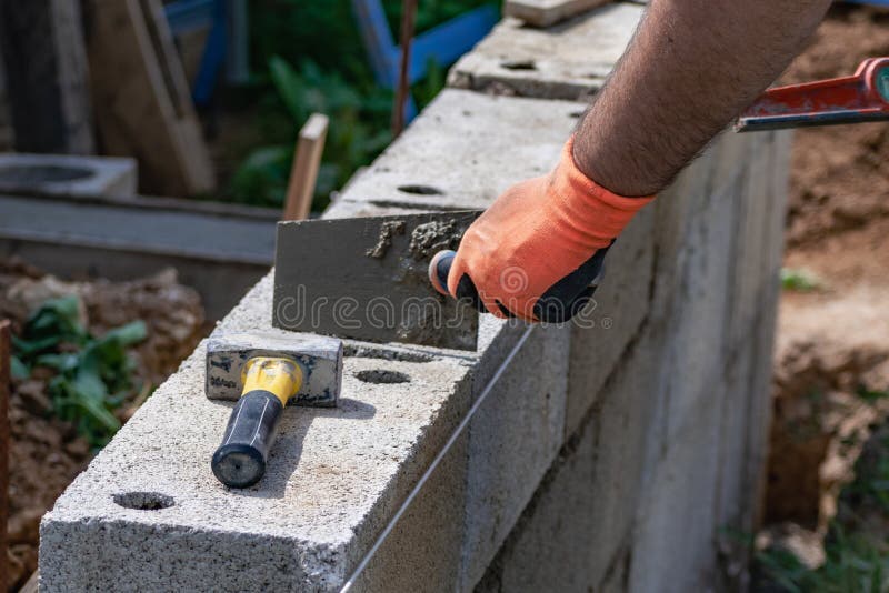 A Bricklayer Works on Blocks To Build a Wall on a Construction Site ...