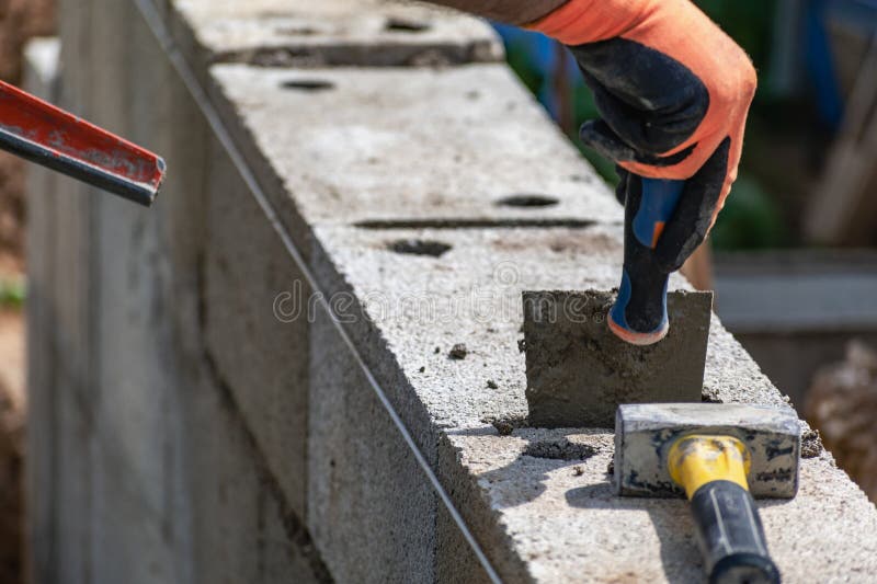 A Bricklayer Works on Blocks To Build a Wall on a Construction Site ...