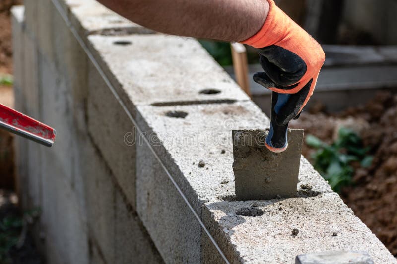 A Bricklayer Works on Blocks To Build a Wall on a Construction Site ...