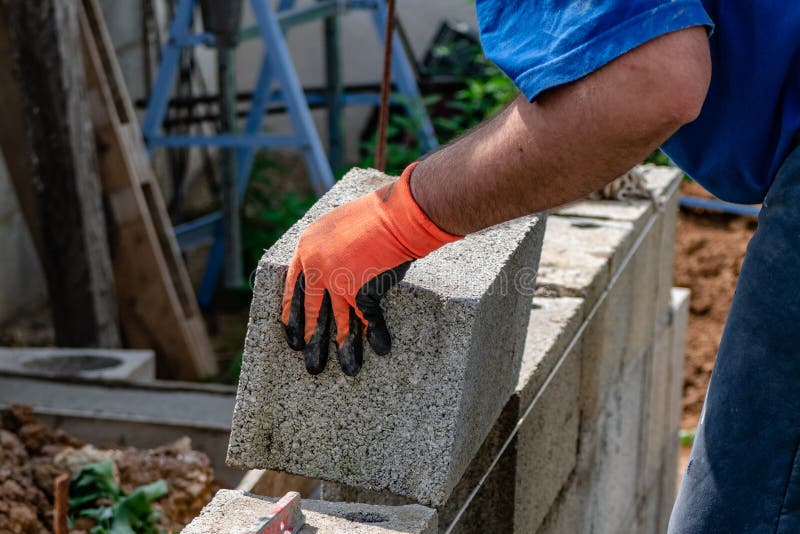 A Bricklayer Works on Blocks To Build a Wall on a Construction Site ...