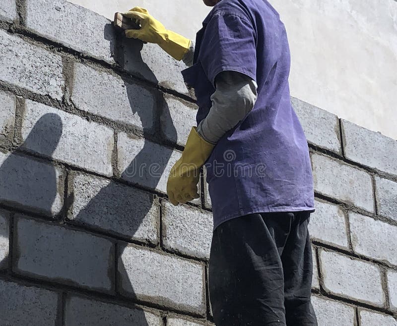 Bricklayers on Construction Scaffolding Passing Wire between Exposed ...