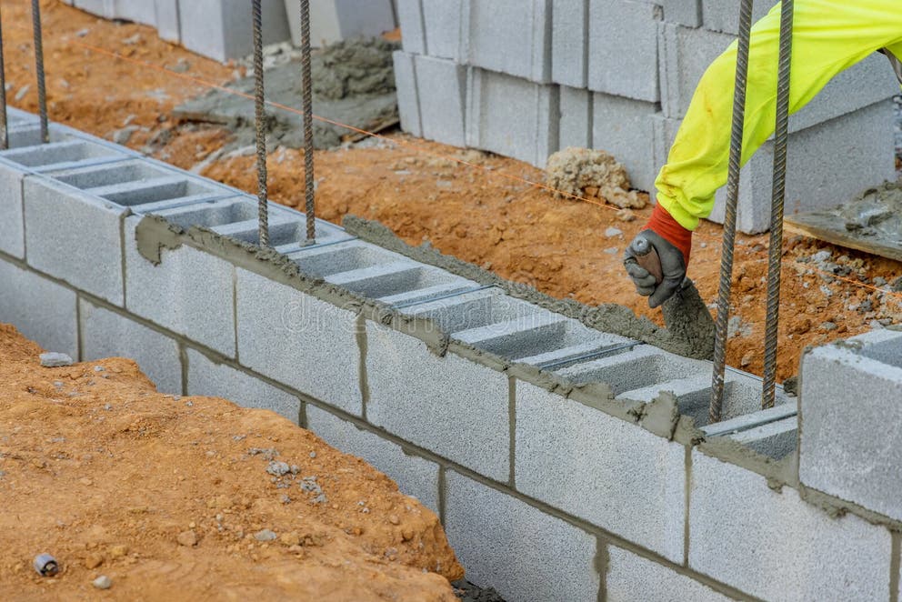Bricklayers are Laying Concrete Blocks in a Wall in Order To Construct ...