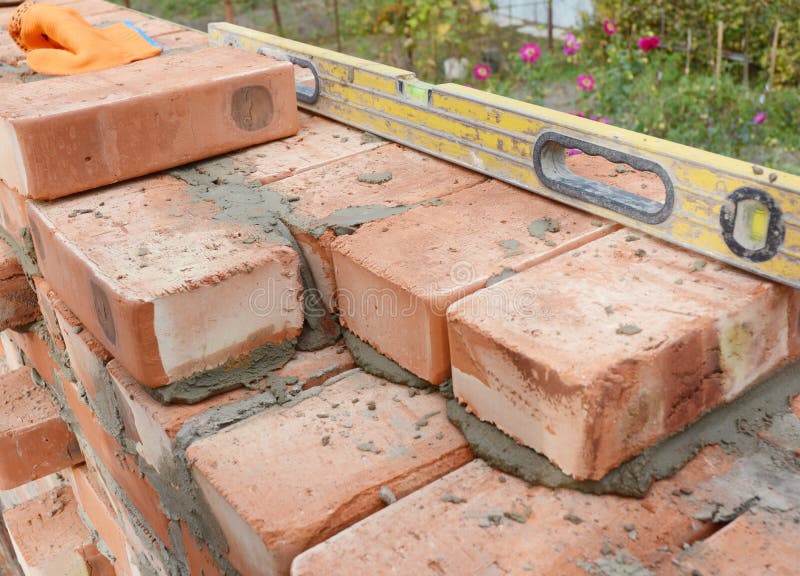 Bricklaying with Spirit Level To Check New Red Brick House Wall. Stock ...