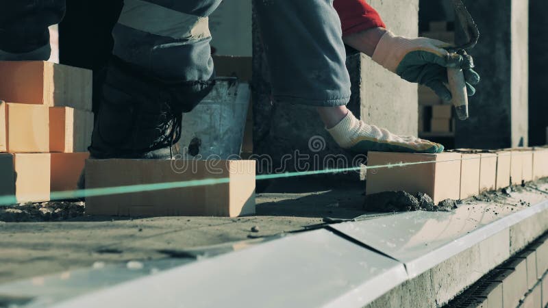 Bricks are Getting Laid on Fresh Cement by a Worker. Construction ...