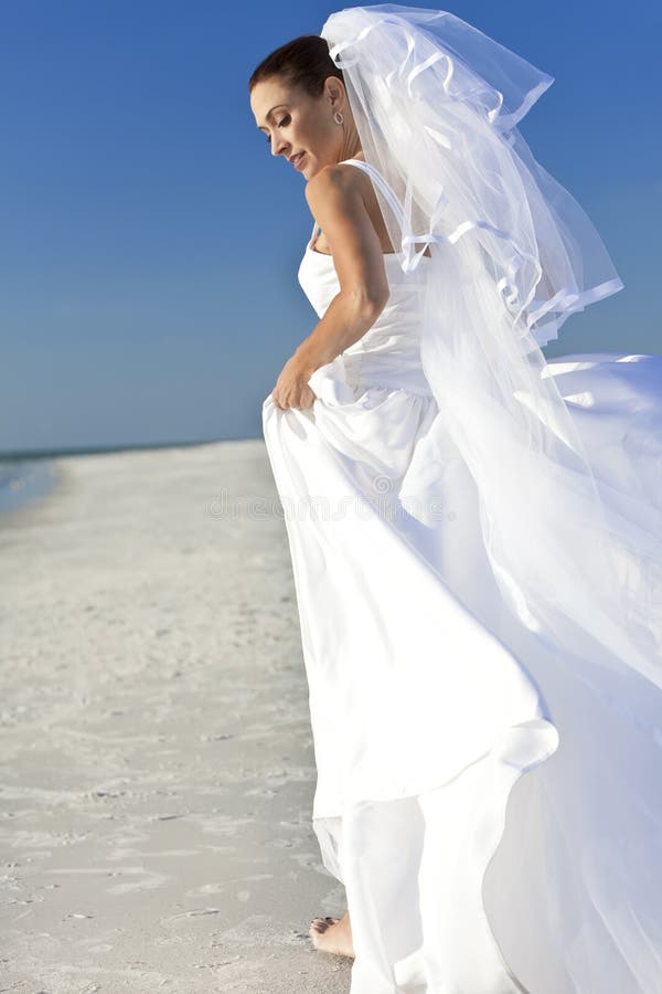 Blonde Bride Walking on the the Beach. Beautiful Woman in Wedding Dress ...