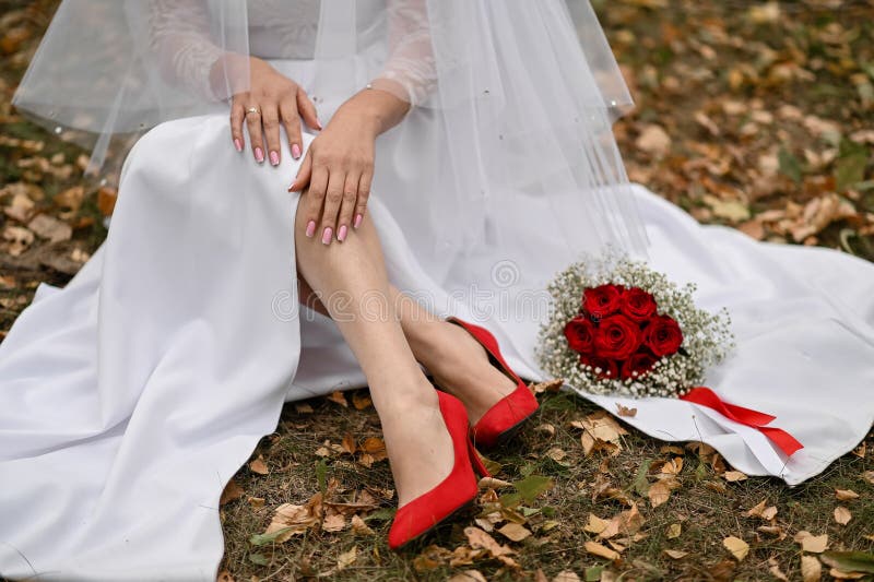 The Bride with a Bouquet of Red Roses. the Bride is Sitting on the ...