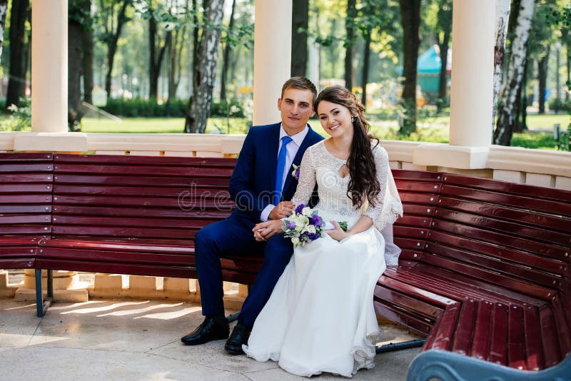 Bride and groom on a bench stock image. Image of flower - 91486519
