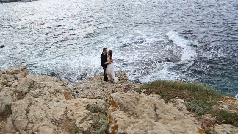 Bride and Groom on a Cliff Above the Ocean Stock Video - Video of ...