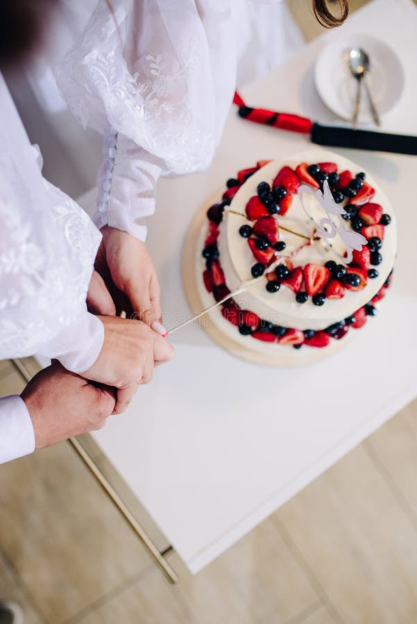The Bride and Groom Cut the First Piece of the Wedding Cake Stock Photo ...