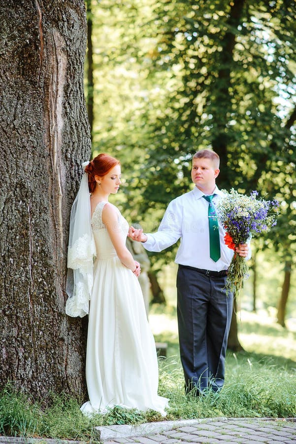Bride and Groom Hold Each Other Hands while they Walk Along the Stock ... Bride and Groom Hold Each Other Hands while they Walk Along the Stock ...