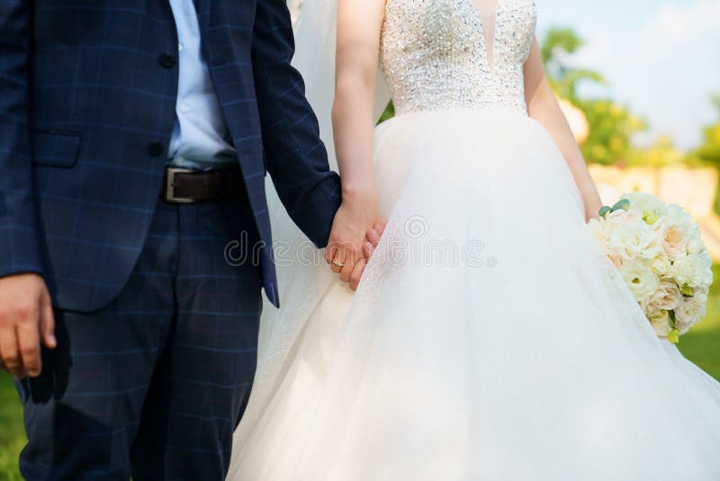 The Bride and Groom Hold Hands on the Street. Stock Photo - Image of ...