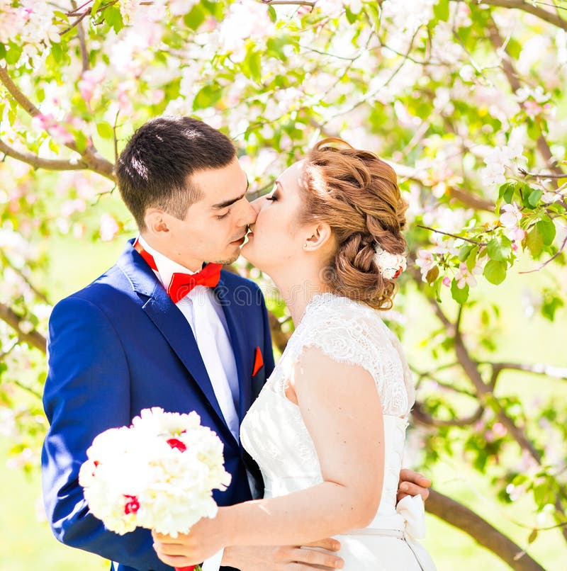 The Bride and Groom Kissing in the Spring Nature with Blooming Trees ...