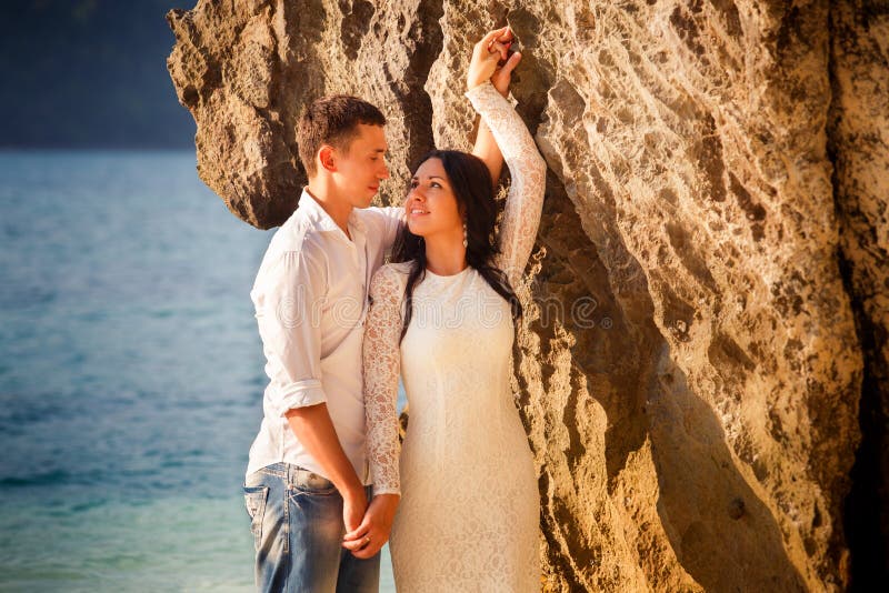 Bride and Groom Lean Against Rock Stock Photo - Image of honeymoon ...