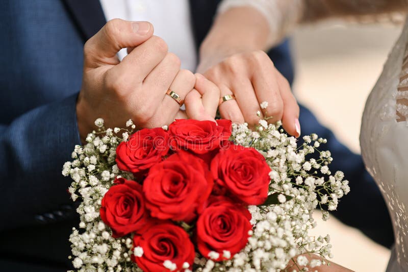 The Bride and Groom with Red Roses. Holding Hands Stock Image - Image ...