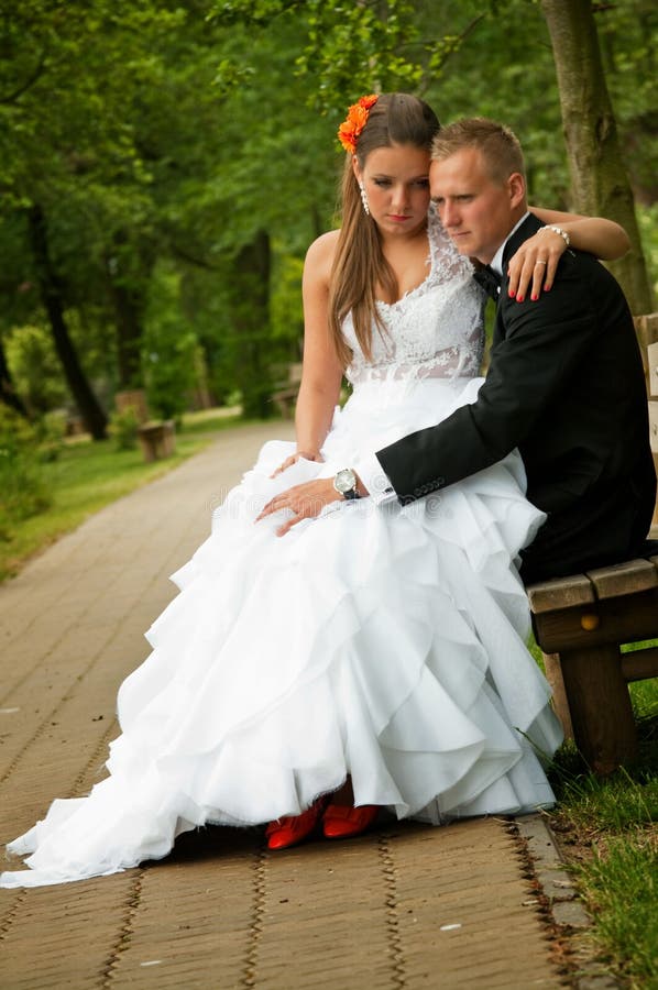 Bride and Groom Seated in Park Stock Photo - Image of green, reflective ...