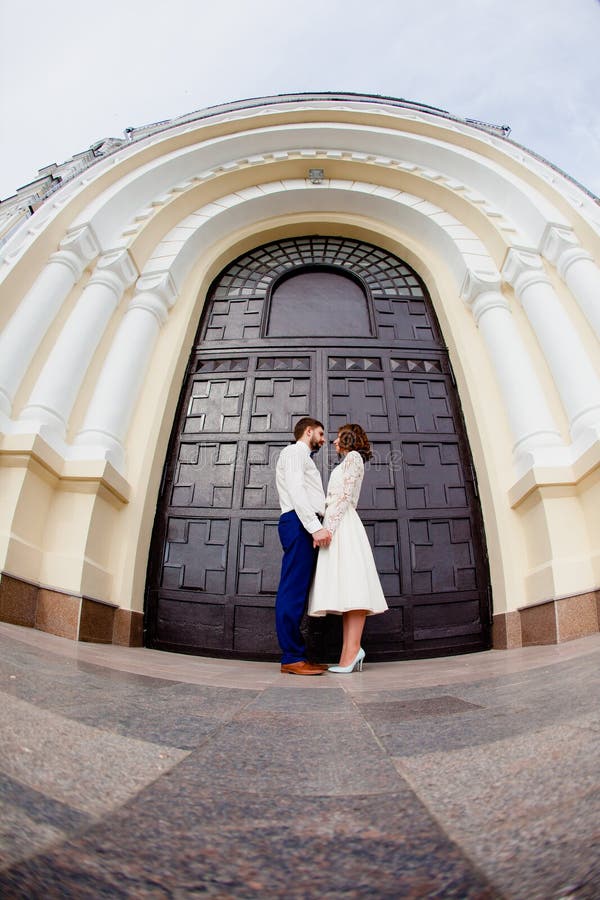 The Bride and Groom Standing Next To the Large Gates Stock Photo ...