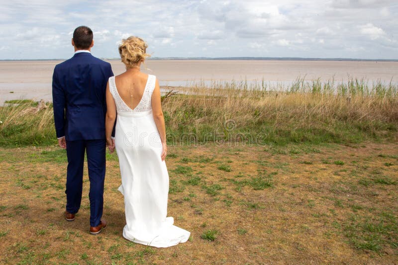 Bride and Groom on Their Wedding Day Outdoors Aside River in Back Rear ...